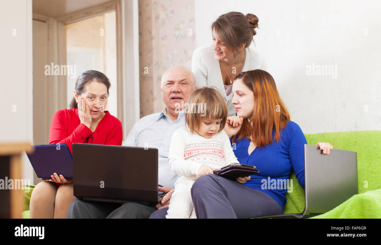 Happy family of with various portable computers on sofa at home Stock ...