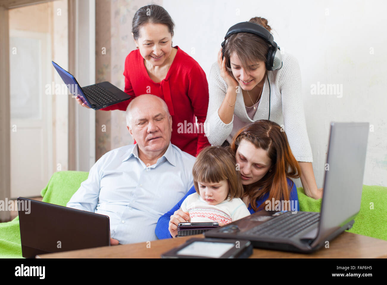 family uses few various electronic devices in home interior Stock Photo ...