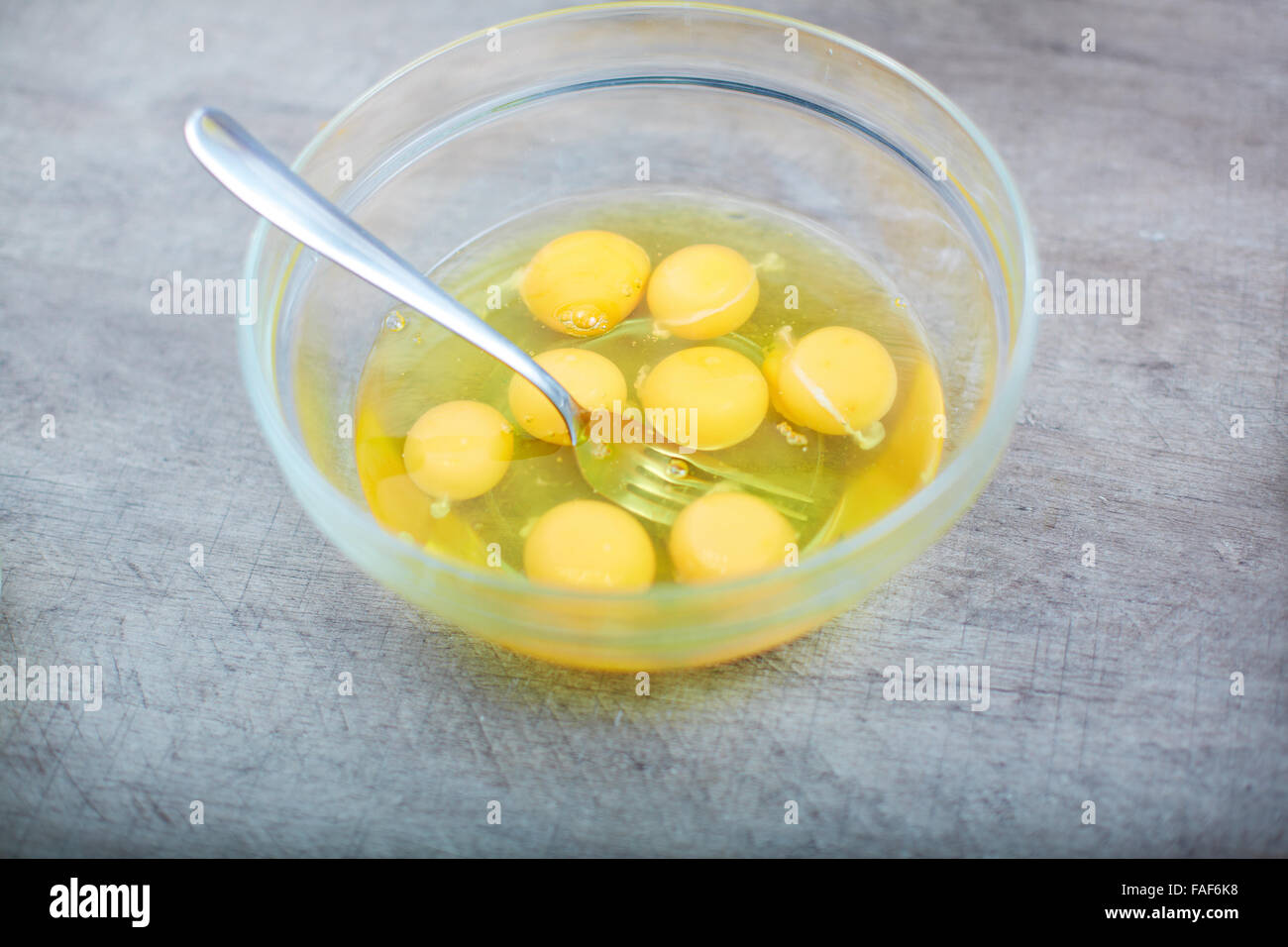 Mixing eggs with fork in bowl Stock Photo - Alamy