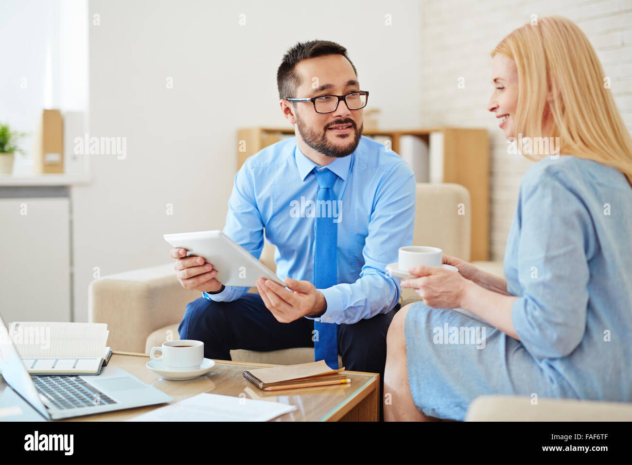 Two business colleagues discussing plans and drinking coffee Stock ...