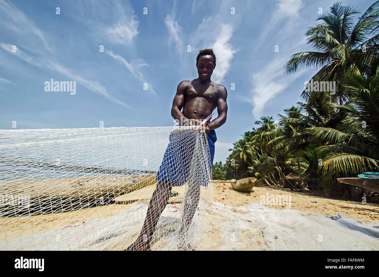 Fisherman fixing his nets on the beach on Yele Island, the Turtle ...