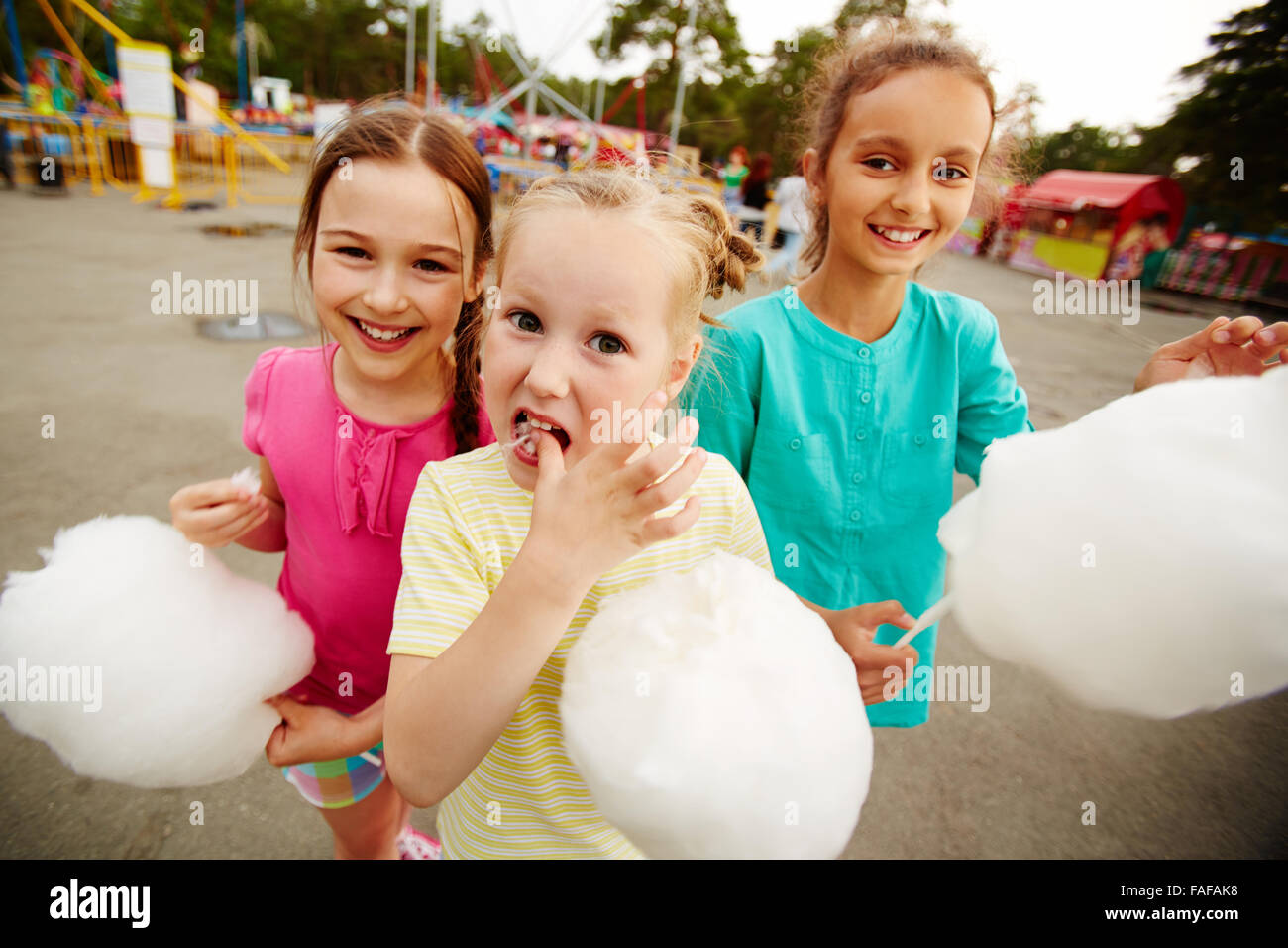 Happy girls eating cotton candy in the park Stock Photo - Alamy