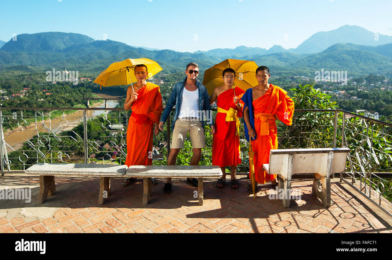 Western tourist posing for a photograph with Buddhist Monks in Luang ...