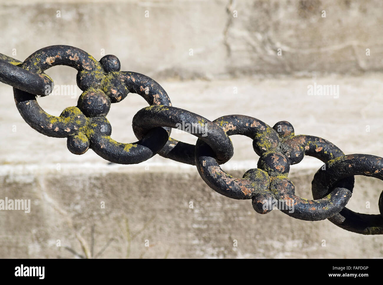 Old metal chain in front of a concrete wall Stock Photo - Alamy