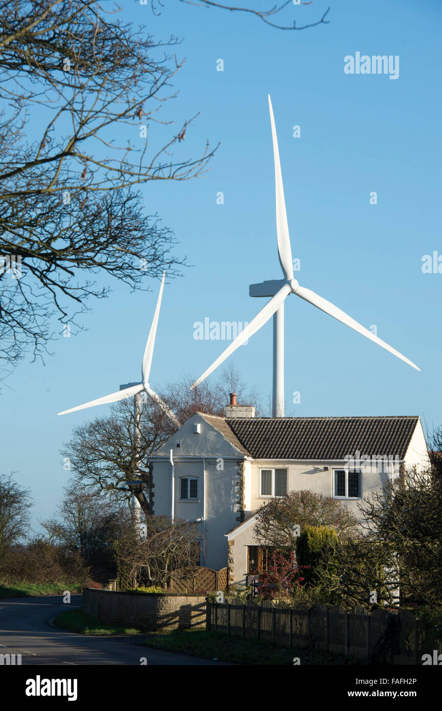Penny Hill Wind Farm rises over one of the houses in the village of ...
