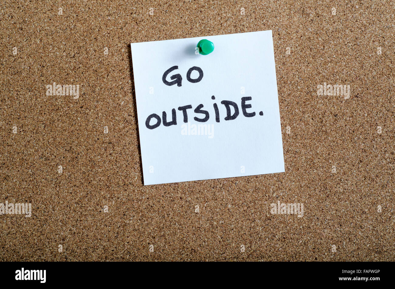 Note paper with green pin on the cork board. Go outside Stock Photo - Alamy