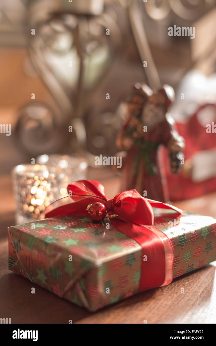 Wrapped Christmas present on a table, with other Christmas objects ...