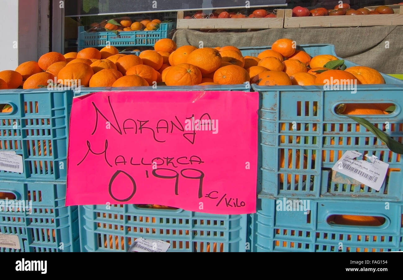 Fresh oranges on display in blue boxes with price tag outside a store ...