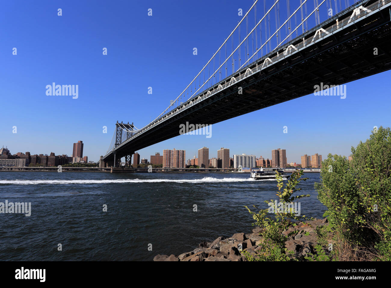 Ferry passing under the Manhattan Bridge East River New York City Stock ...