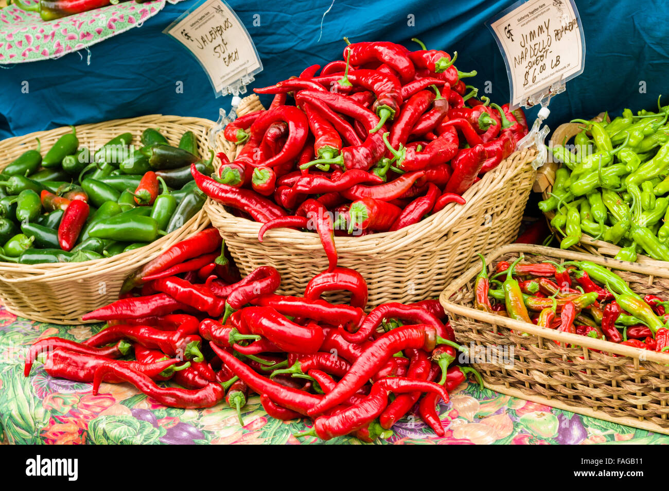 Baskets of red and green hot peppers on display at a farmer's market in ...