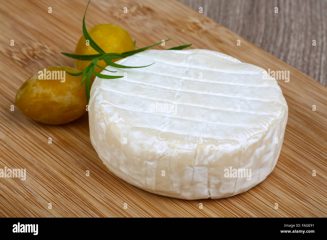Round Brie cheese with yellow plums and estragon Stock Photo - Alamy