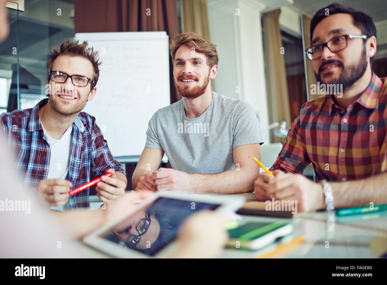 Group of young businessmen listening to speech of their colleague Stock ...