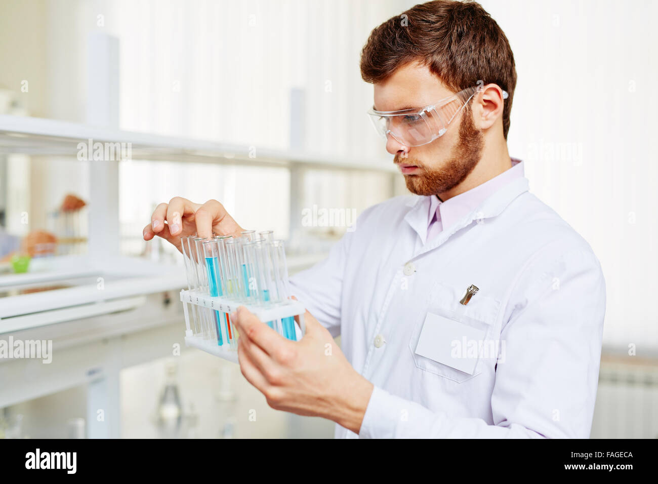 Chemist with flasks making experiment in scientific lab Stock Photo - Alamy
