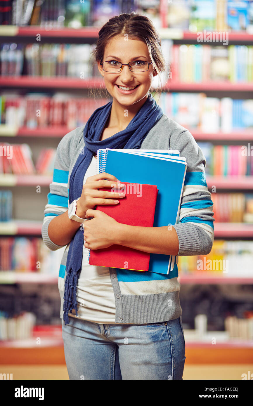 Pretty teenager with books visiting library Stock Photo - Alamy