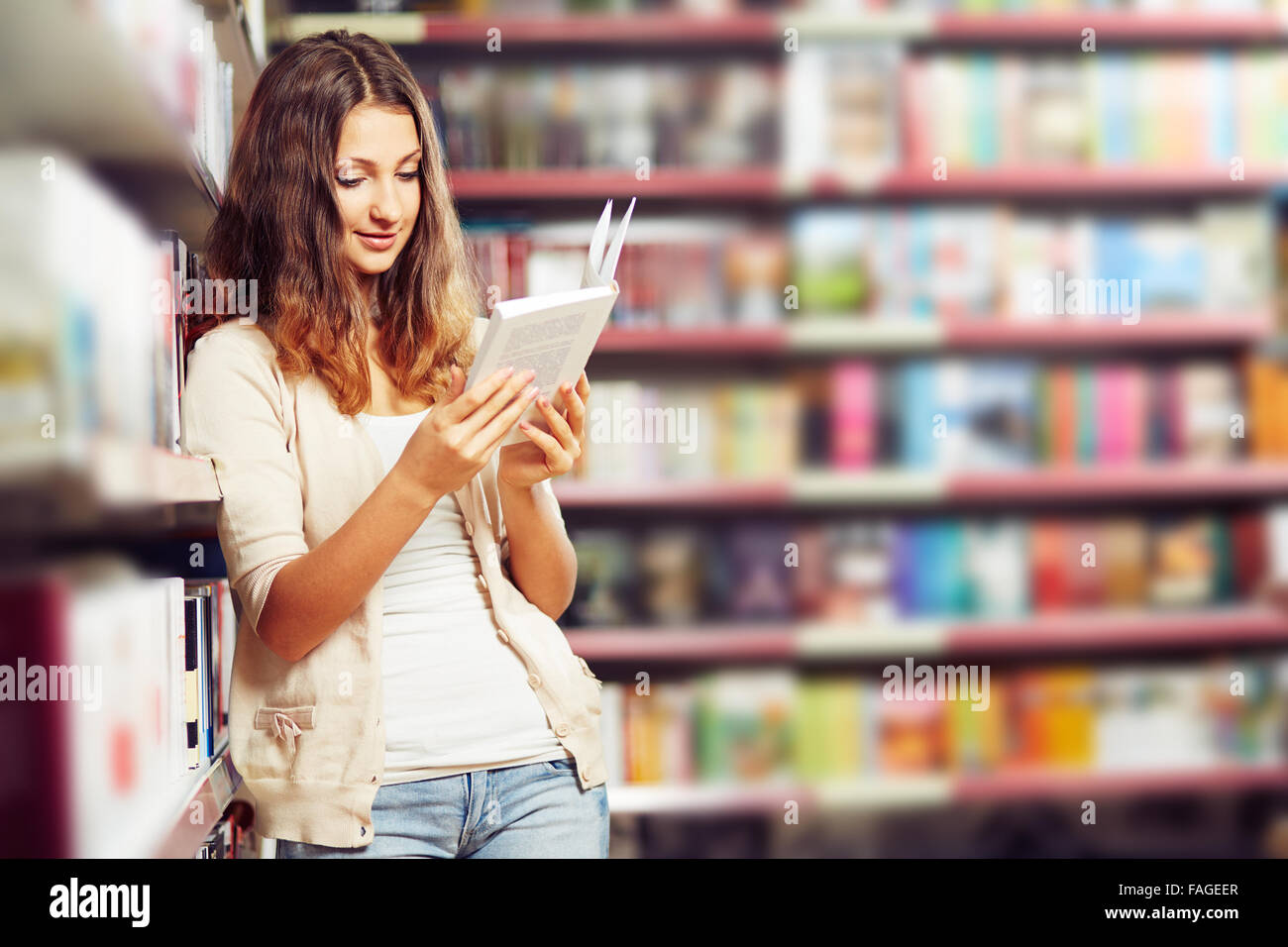 Modern student reading book in college library Stock Photo - Alamy