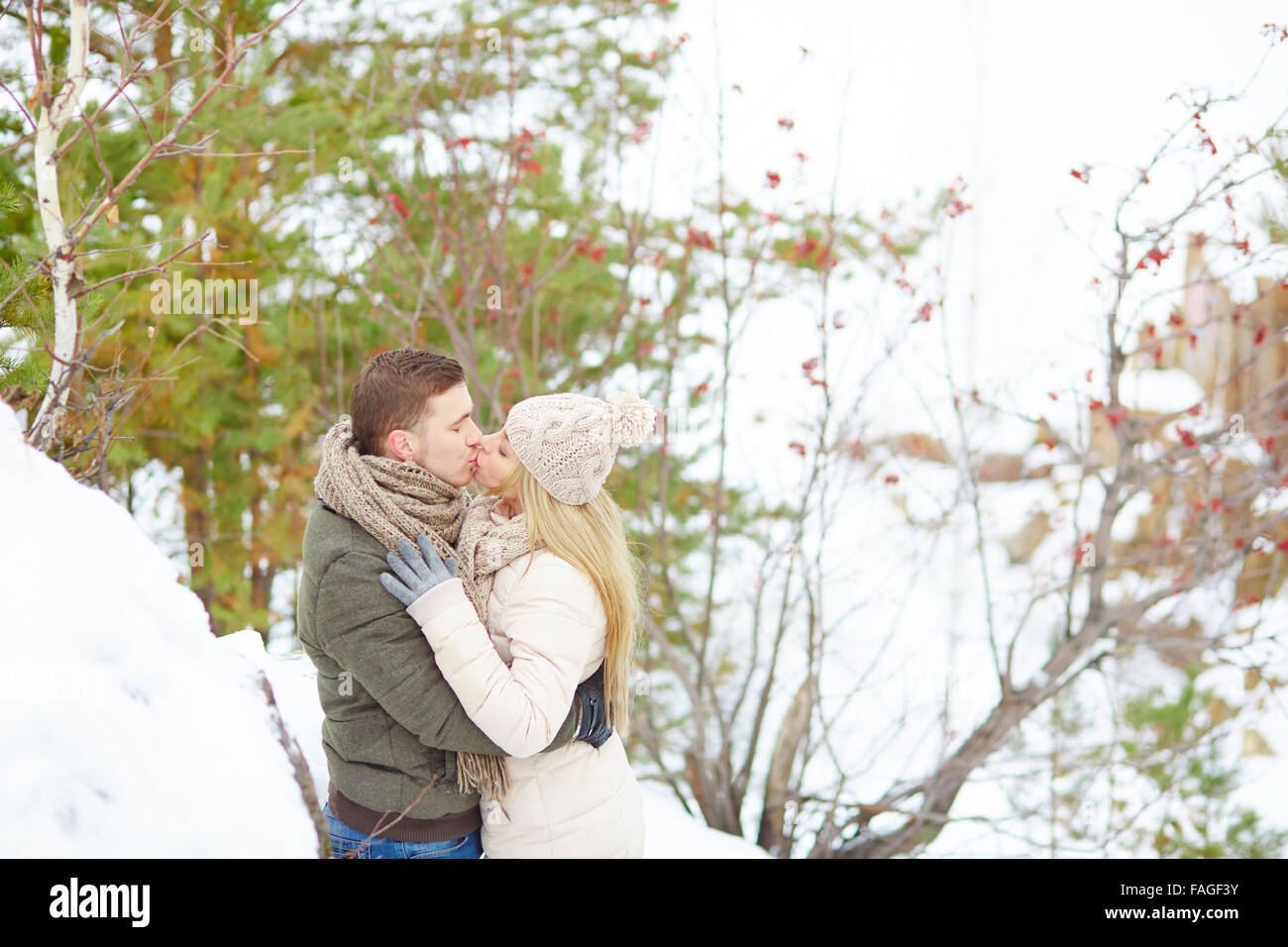 Young couple kissing in winter park Stock Photo - Alamy