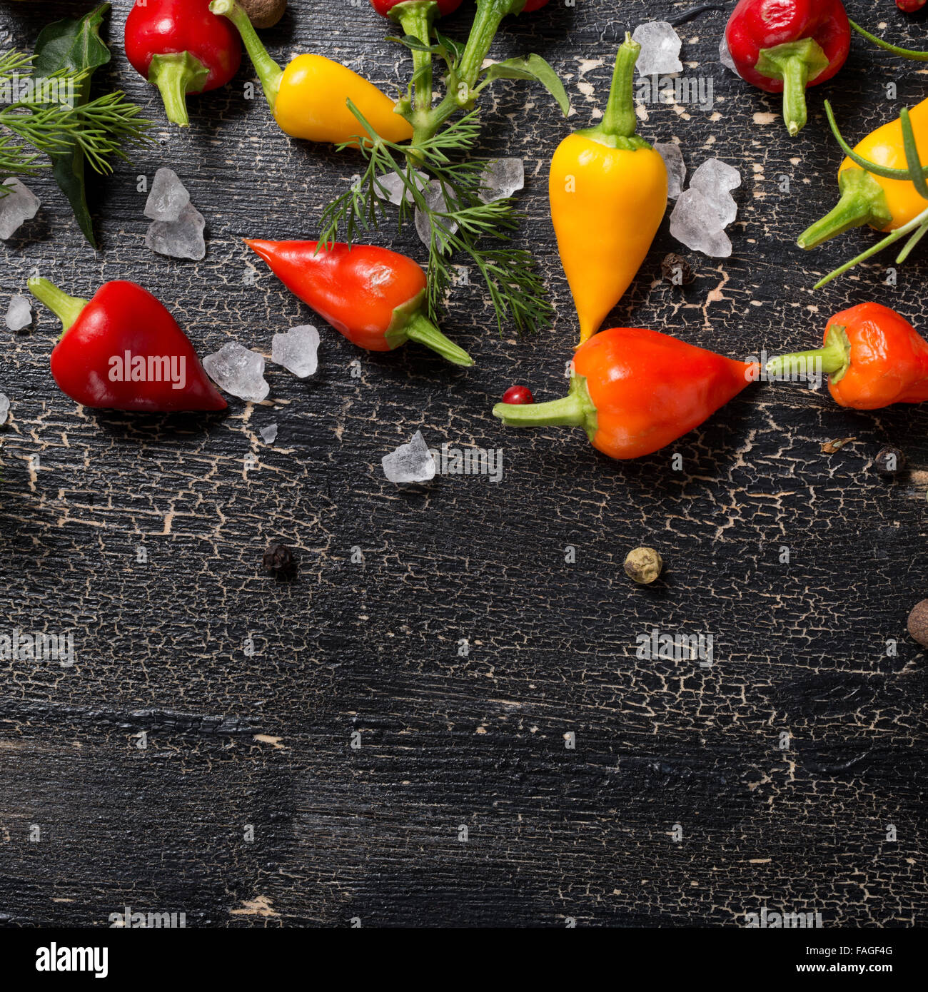 top down of yellow, orange and red hot chili peppers, sea salt ...