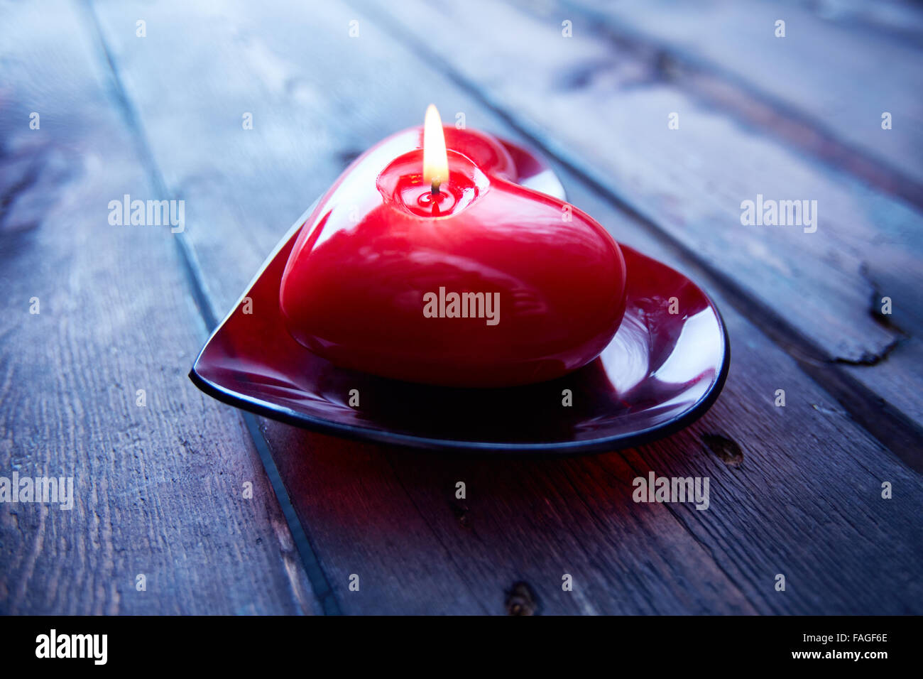 Burning red heart-shaped candle Stock Photo - Alamy