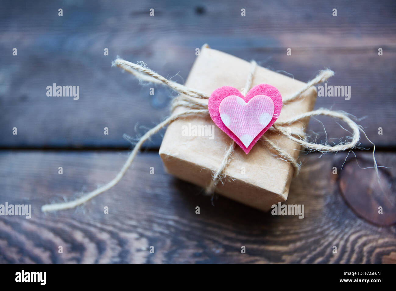 Wrapped package with decorative heart on its top Stock Photo - Alamy