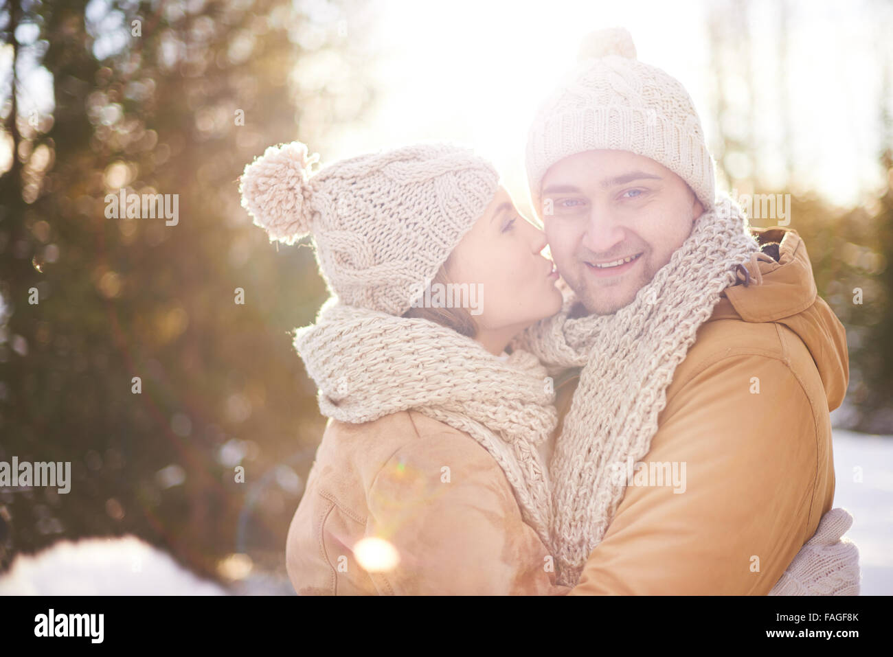 Young woman giving her husband tender kiss Stock Photo - Alamy
