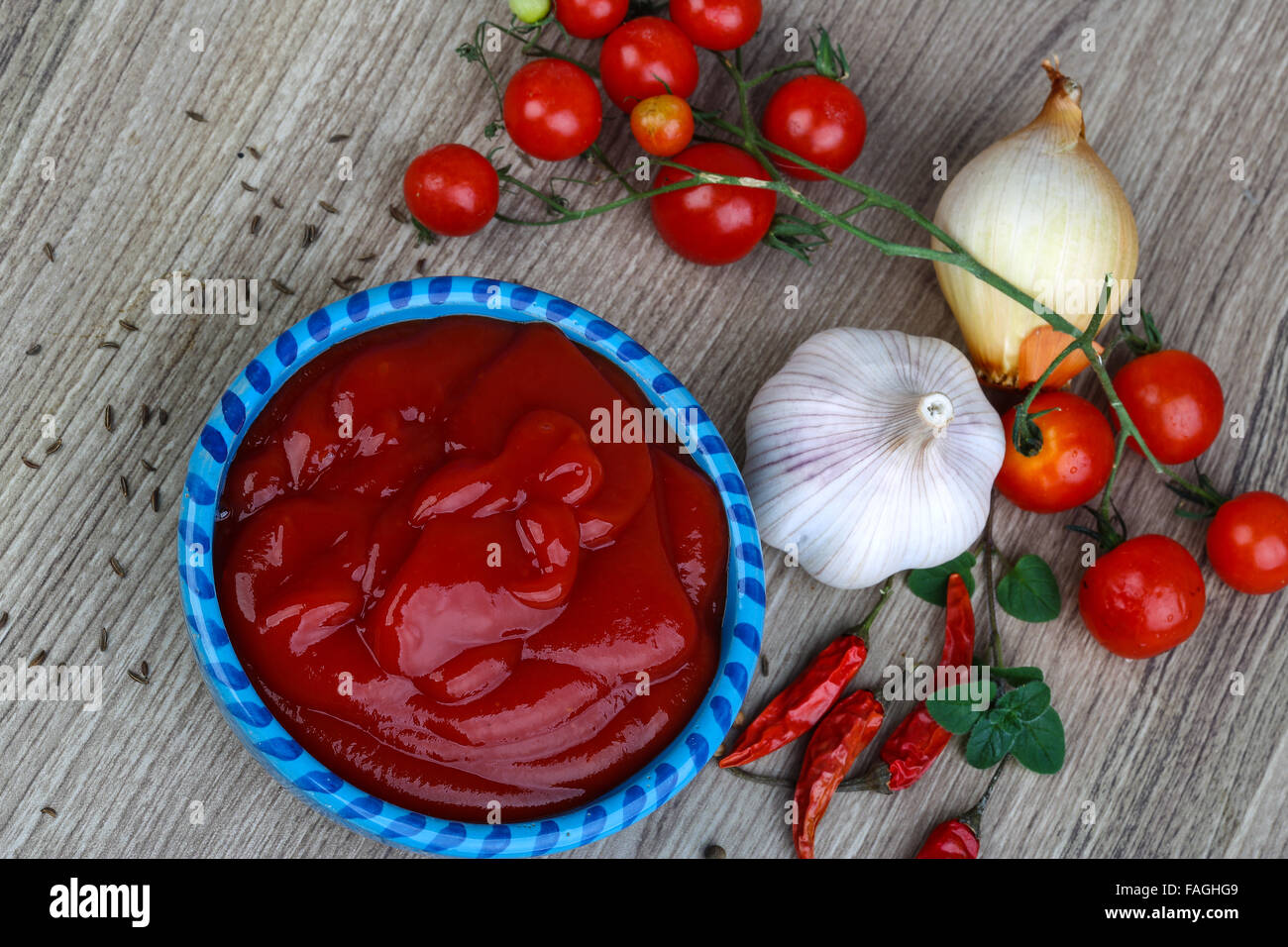 Bright Tomato ketchup with herbs and spices on the wood background ...