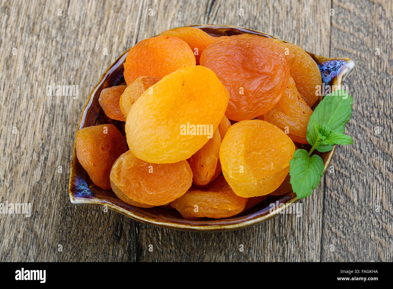 Dried apricots in the bowl on the wood background Stock Photo - Alamy