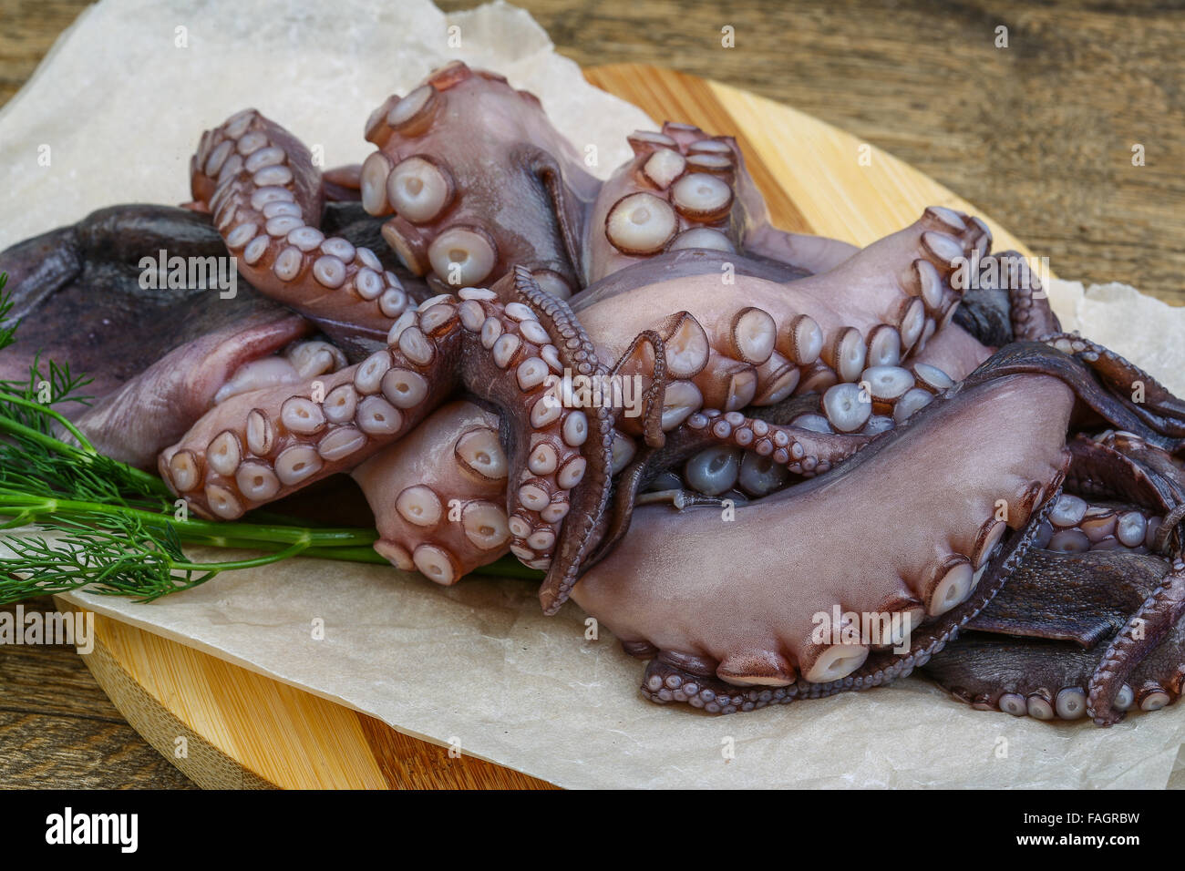 Raw octopus on the wood background ready for cooking Stock Photo - Alamy