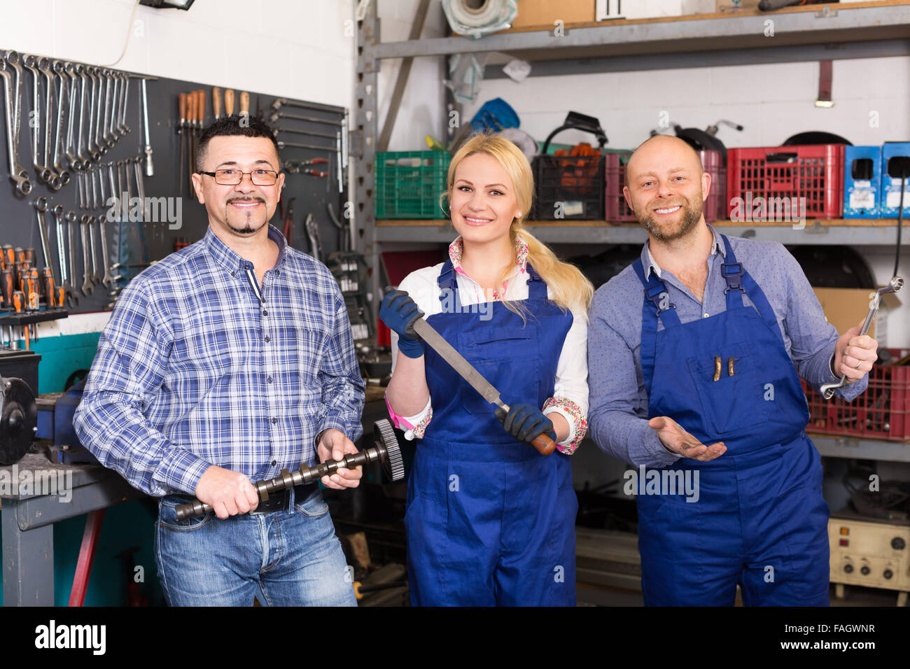 Portrait of auto service center crew with young female near tools and ...