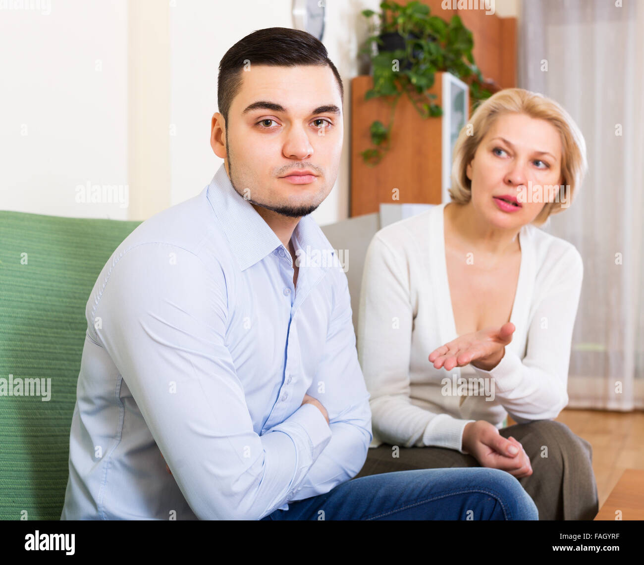 Mature woman explaining something to offended young man Stock Photo - Alamy