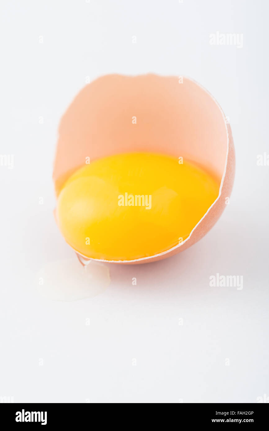 Half of egg with running yolk on the surface Stock Photo - Alamy