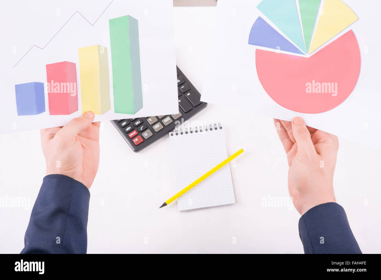 Male hands holding two coloured graphs Stock Photo - Alamy