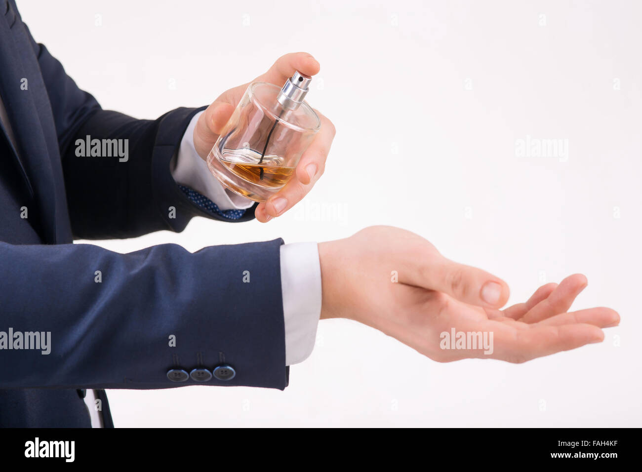 Man spraying perfume on his wrist Stock Photo - Alamy