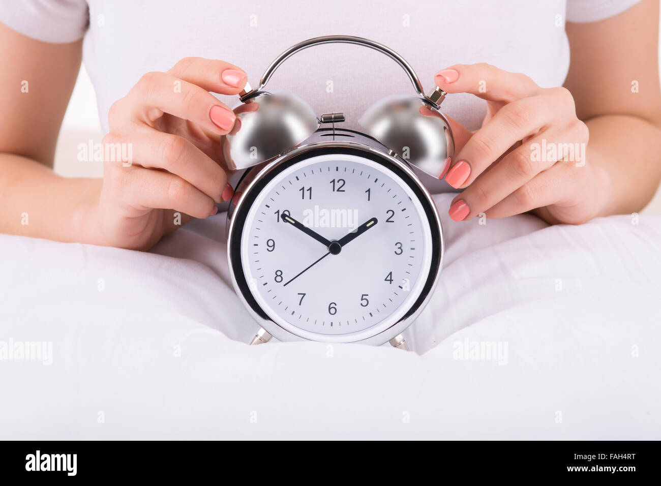 Female hands and alarm clock Stock Photo - Alamy