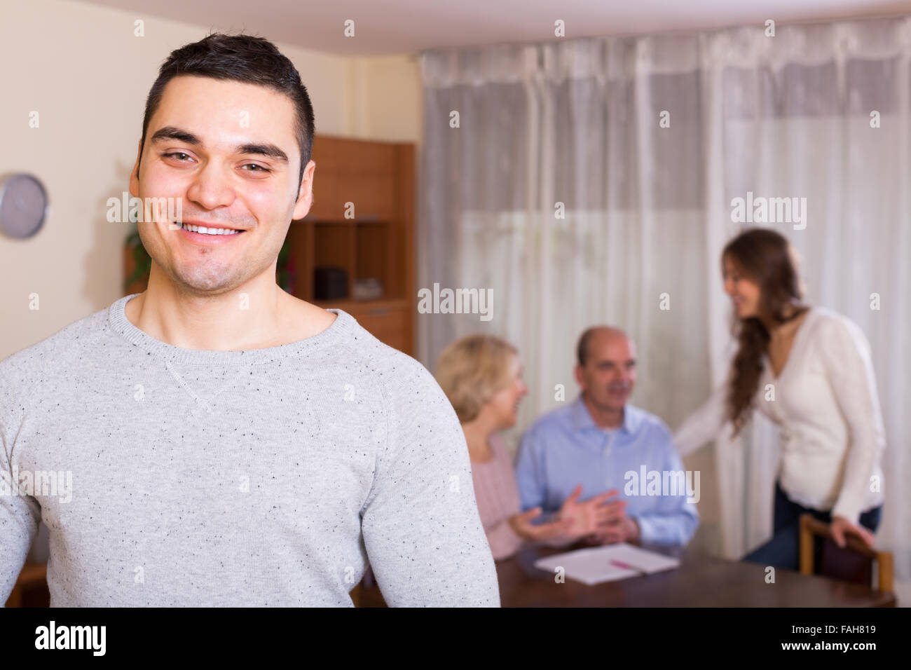 Adult smiling man staying near united family members Stock Photo - Alamy