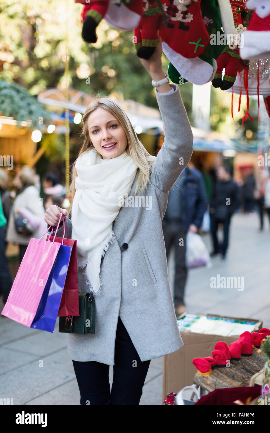 Positive blonde female shopping at festive fair before Xmas Stock Photo ...