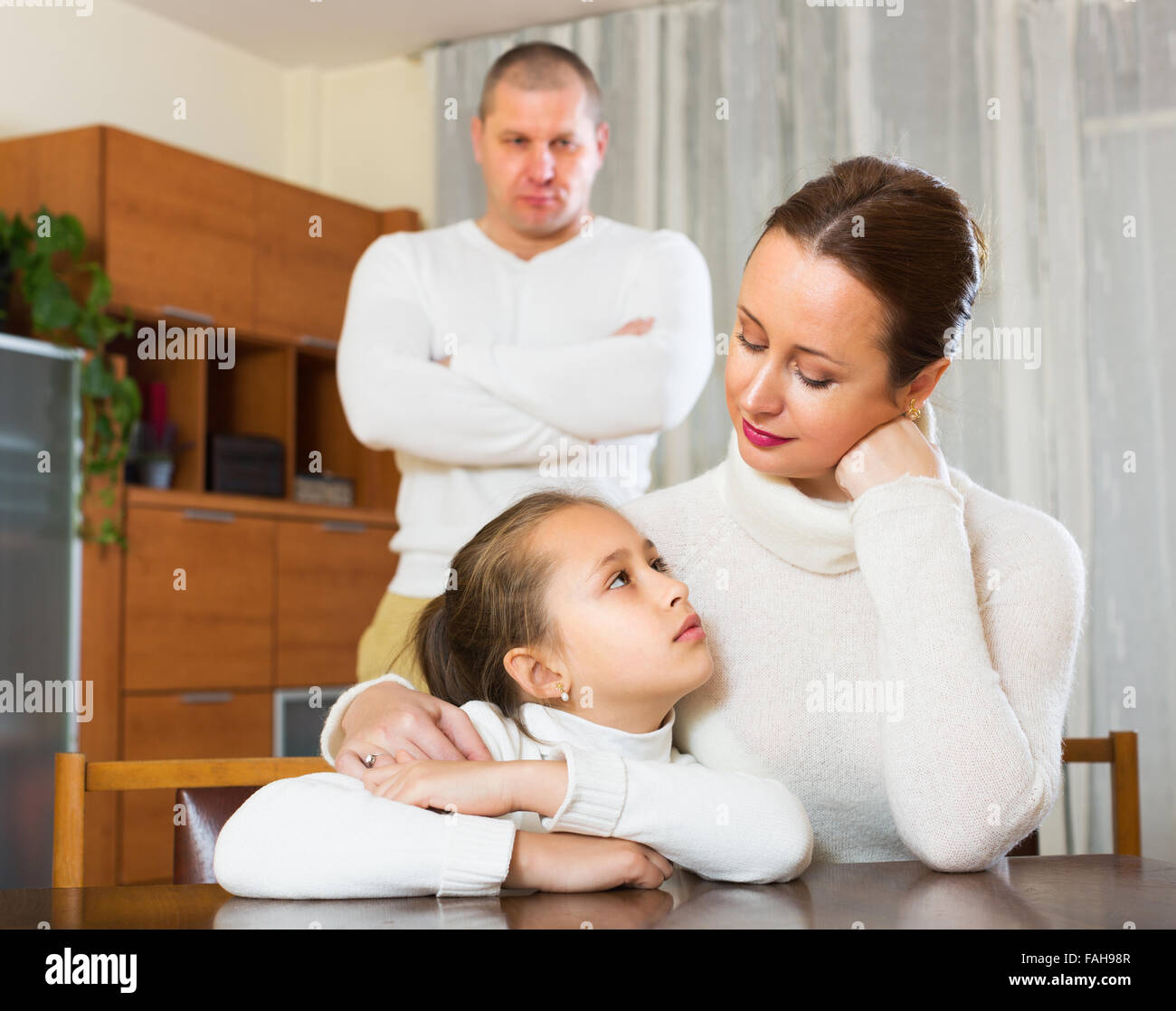 Daughter comforting sad mother at home and angry father Stock Photo - Alamy