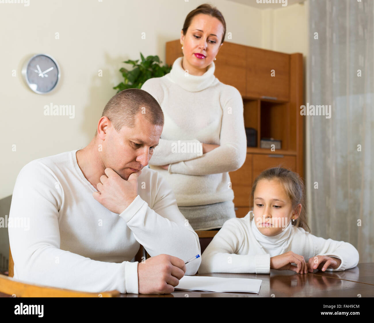 Poor family counting money to pay bills at the table. Focus on man ...