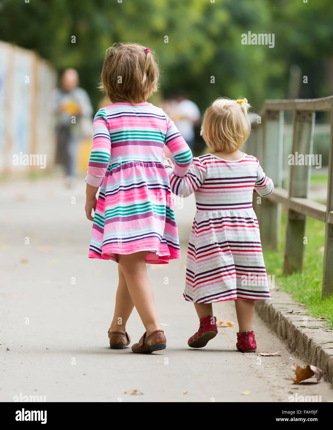 Rear view of two little girls at street in summer Stock Photo - Alamy