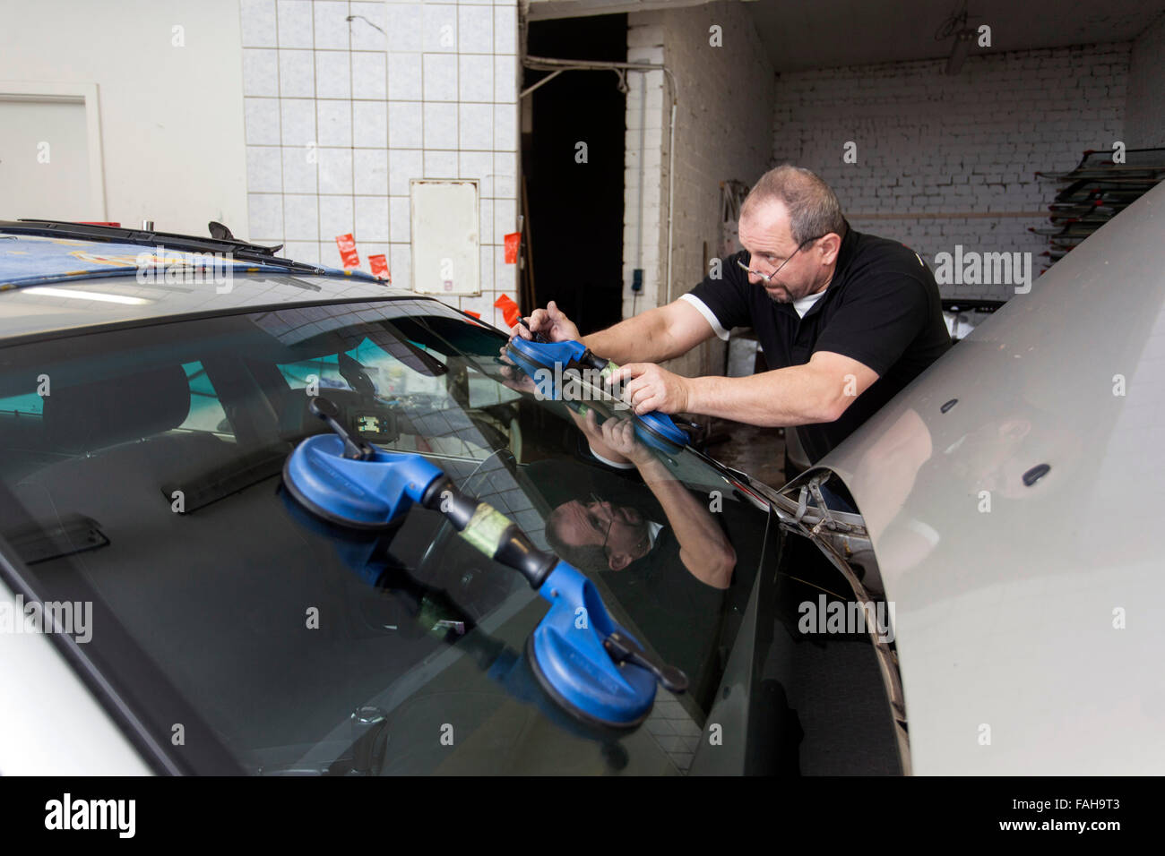 Replace the windscreen in an auto glass workshop Stock Photo - Alamy