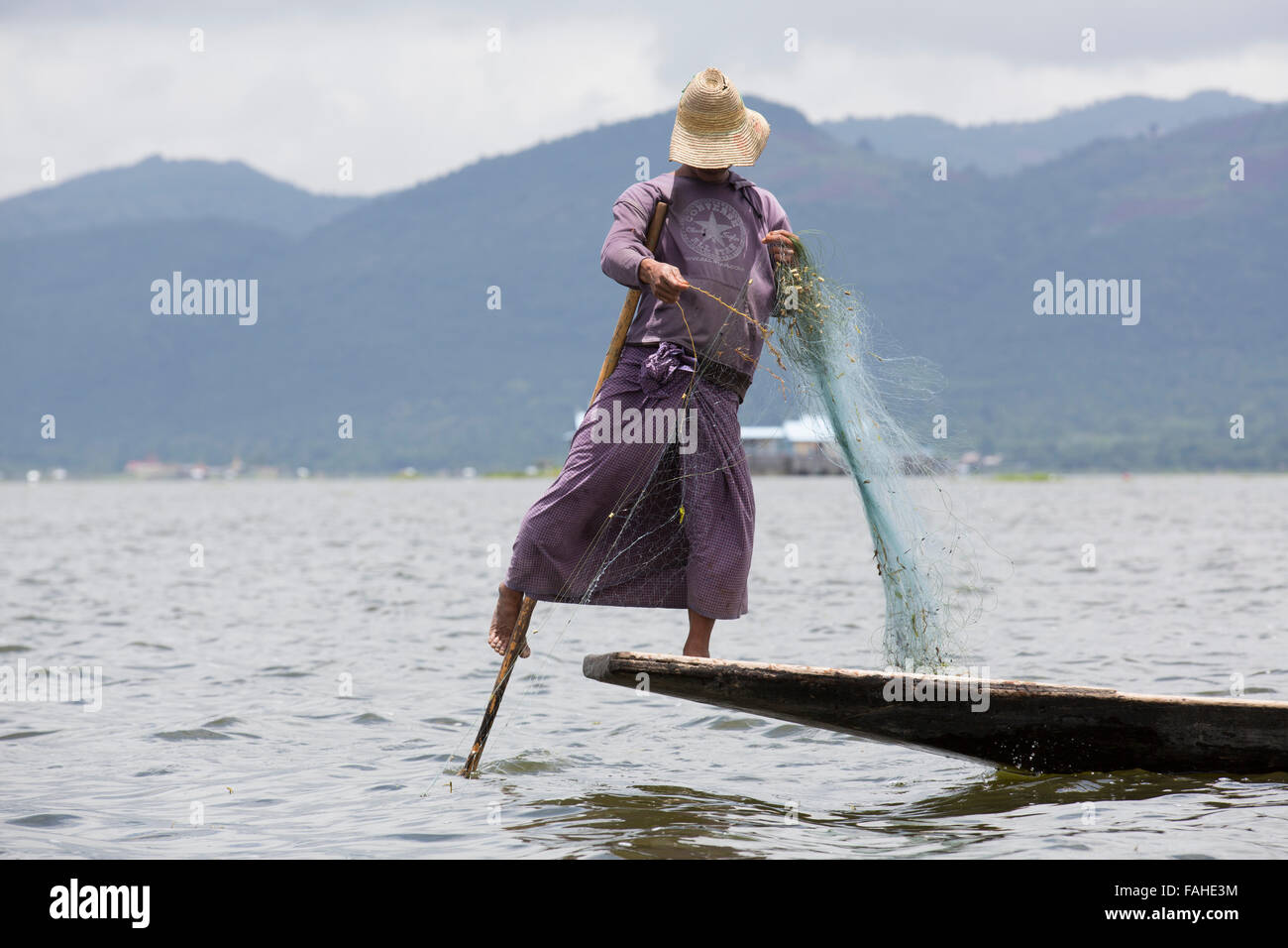 A fisherman from the Intha people rowing his boat on Inle Lake in ...