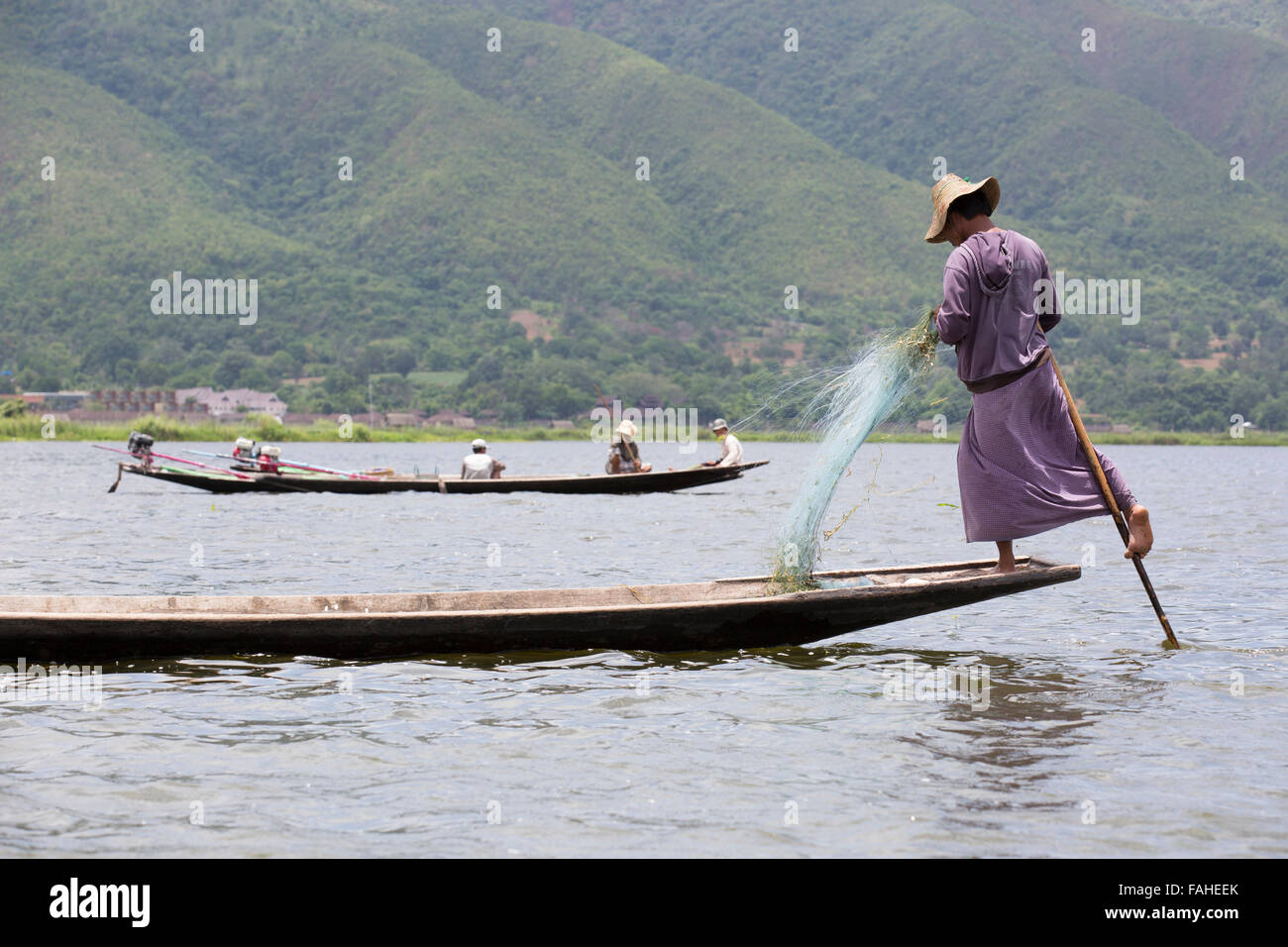 A fisherman from the Intha people rowing his boat on Inle Lake in ...