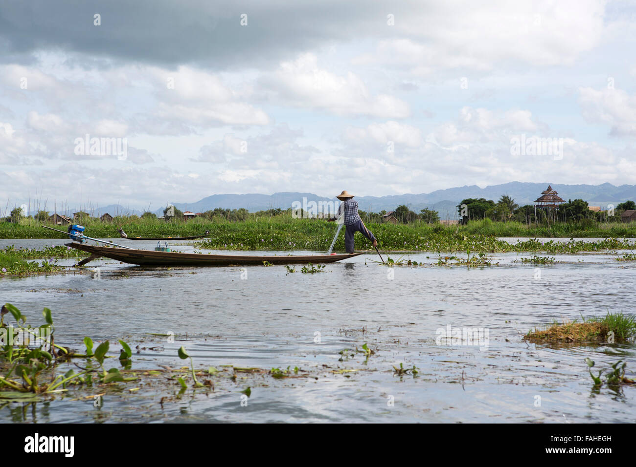 A fisherman from the Intha people rowing his boat on Inle Lake in ...