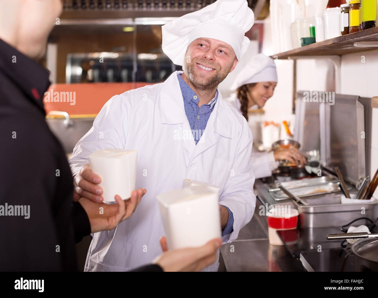 smiling cook and client buying take-away food at eating house Stock ...