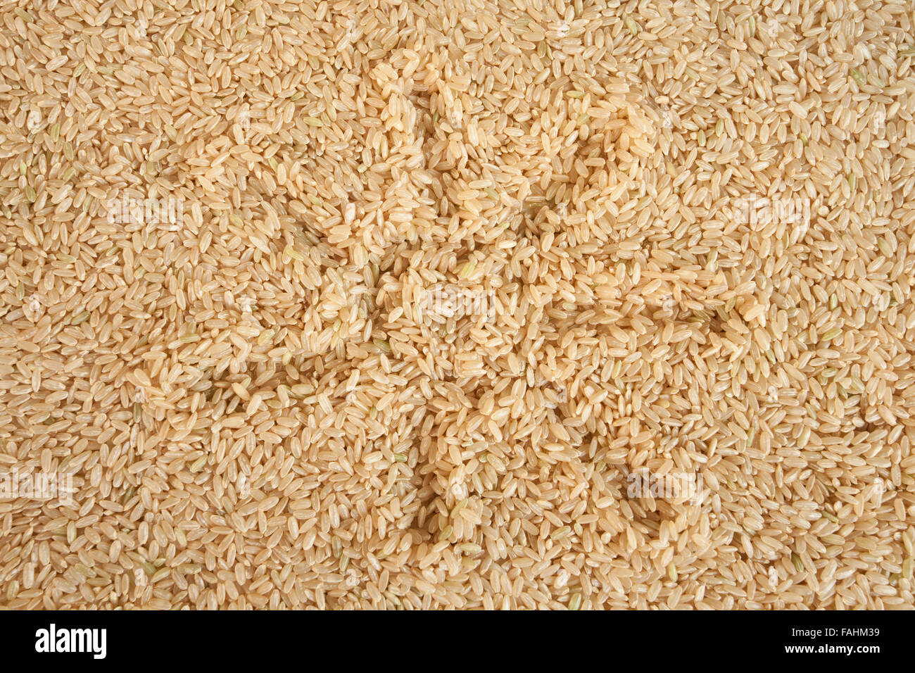 Integral uncooked brown rice with a stylized sun on it Stock Photo - Alamy