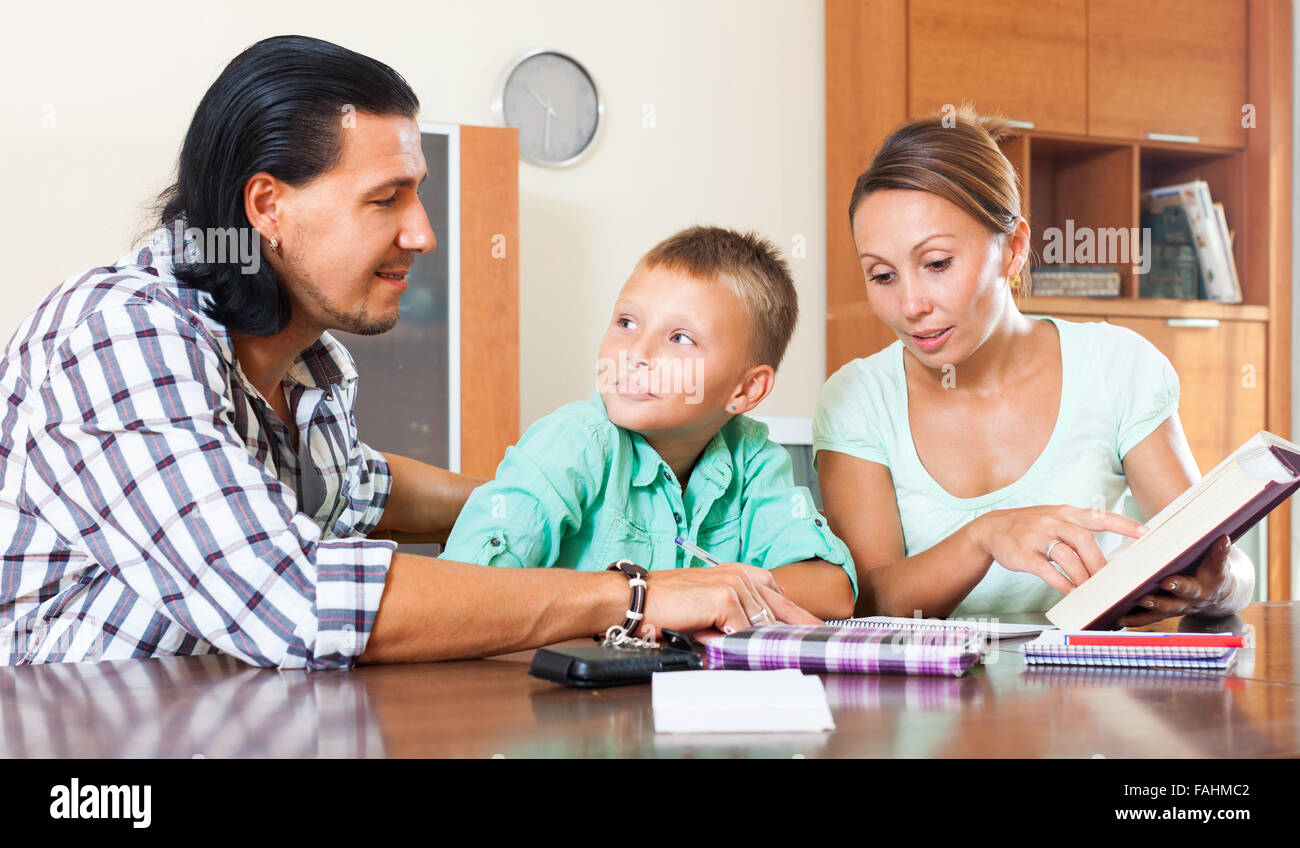 Happy schoolboy studying with parents Stock Photo - Alamy