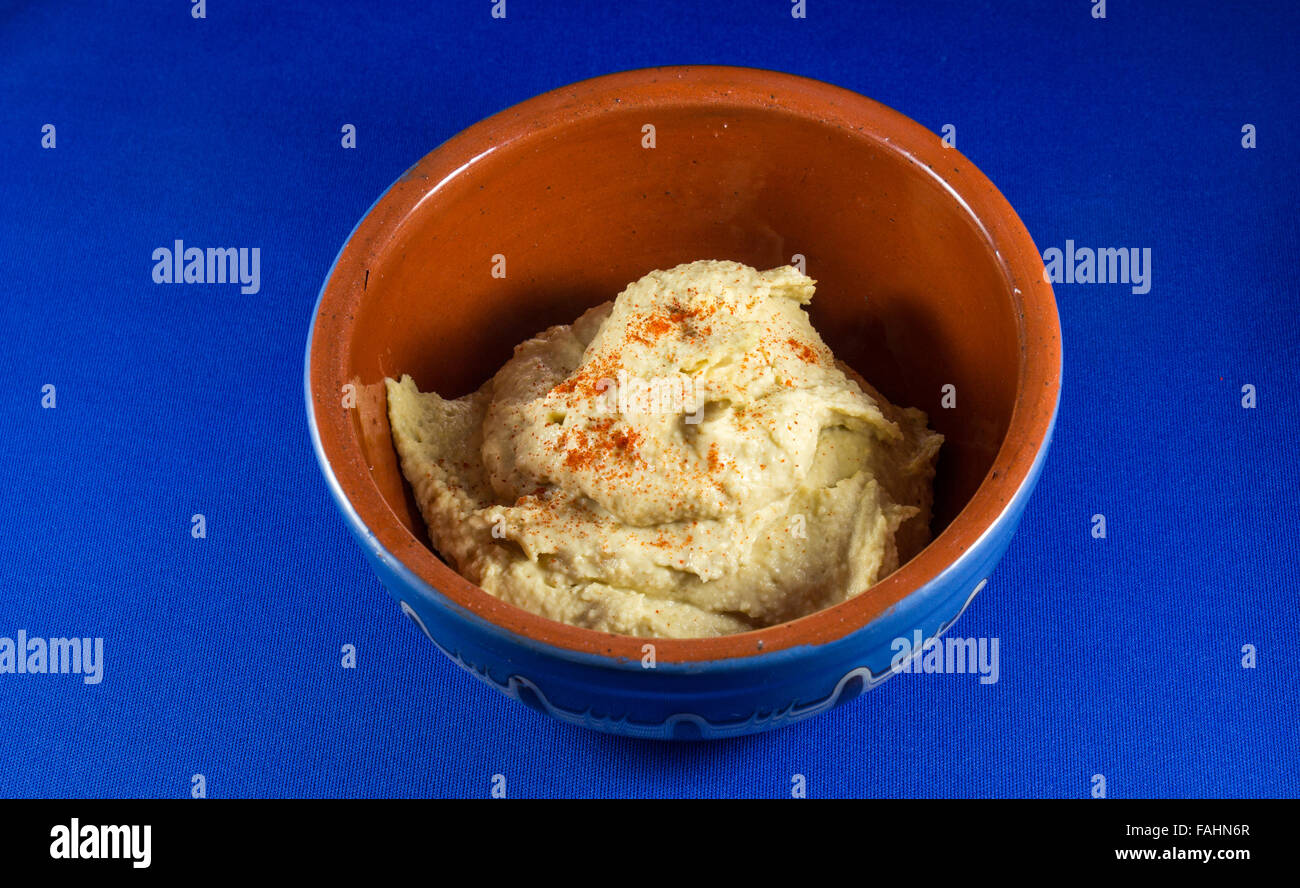 Hummus in traditional bowl with blue landscape background Stock Photo ...