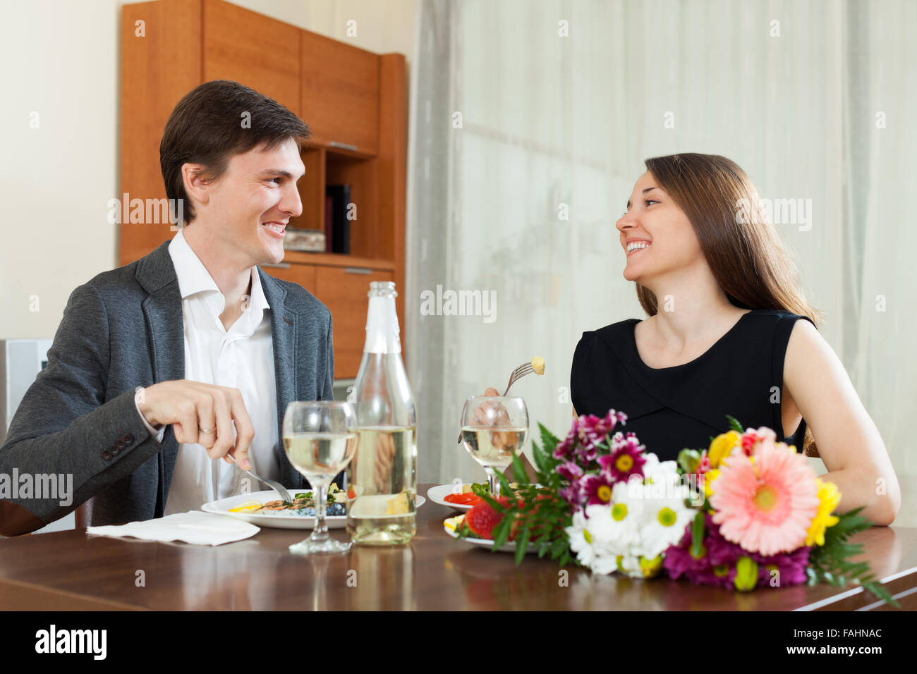 Young guy and girl having romantic dinner with wine in home Stock Photo ...