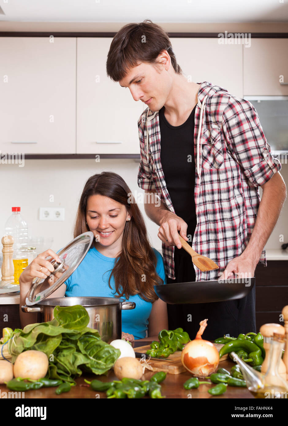 young man and pretty woman cooking together in kitchen Stock Photo - Alamy