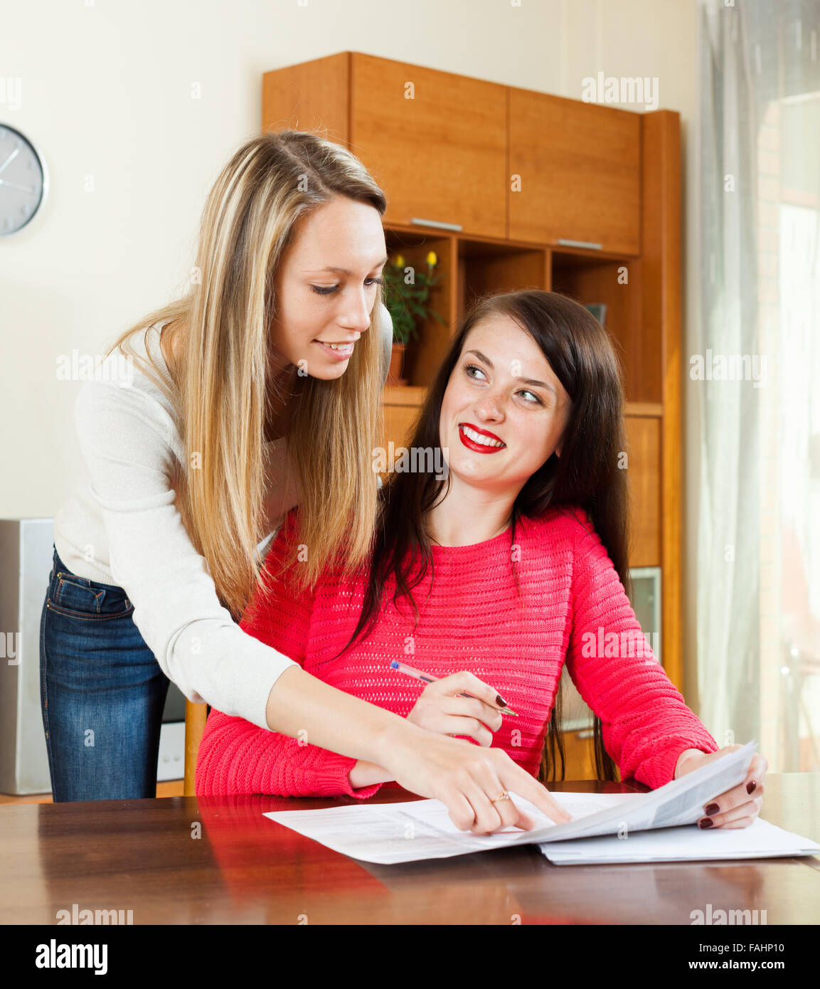 Happy women reading financial documents at table in home interior Stock ...
