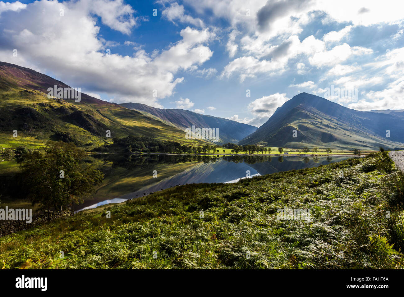 Lake Buttermere reflecting the surrounding hills on a bright sunny ...